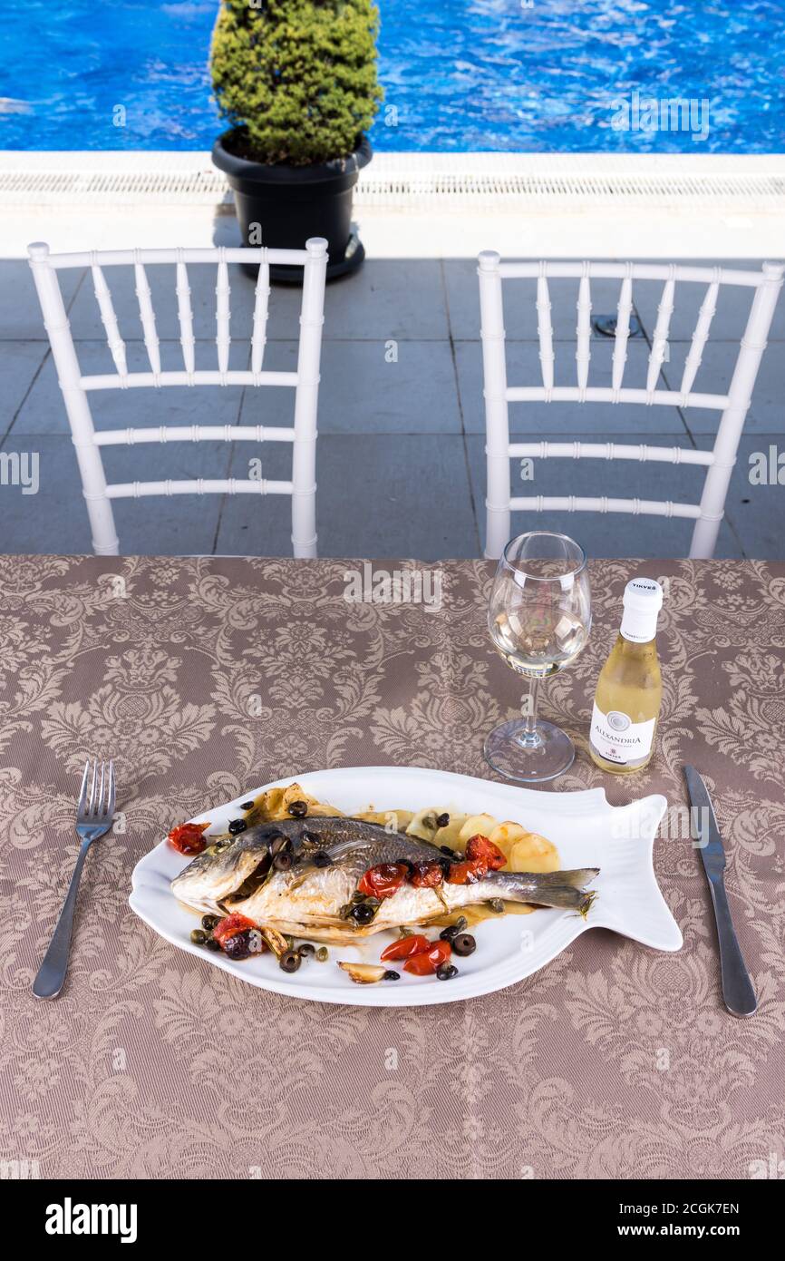 Baked fish served in a fish dish Stock Photo - Alamy