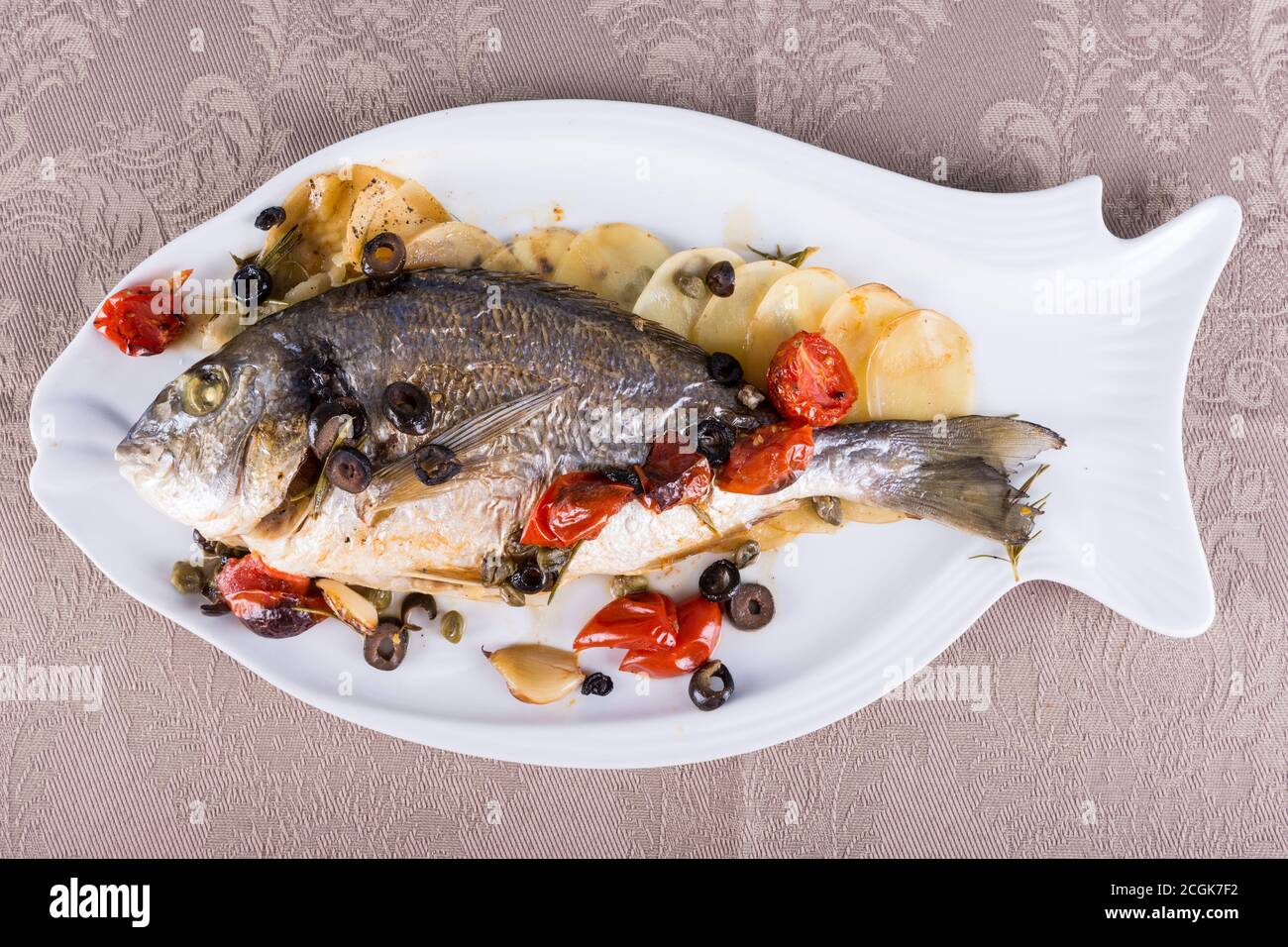 Baked fish served in a fish dish Stock Photo - Alamy