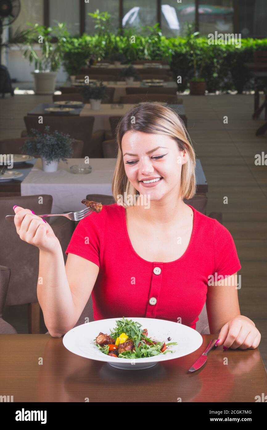 Woman eating main meal with wine Stock Photo - Alamy