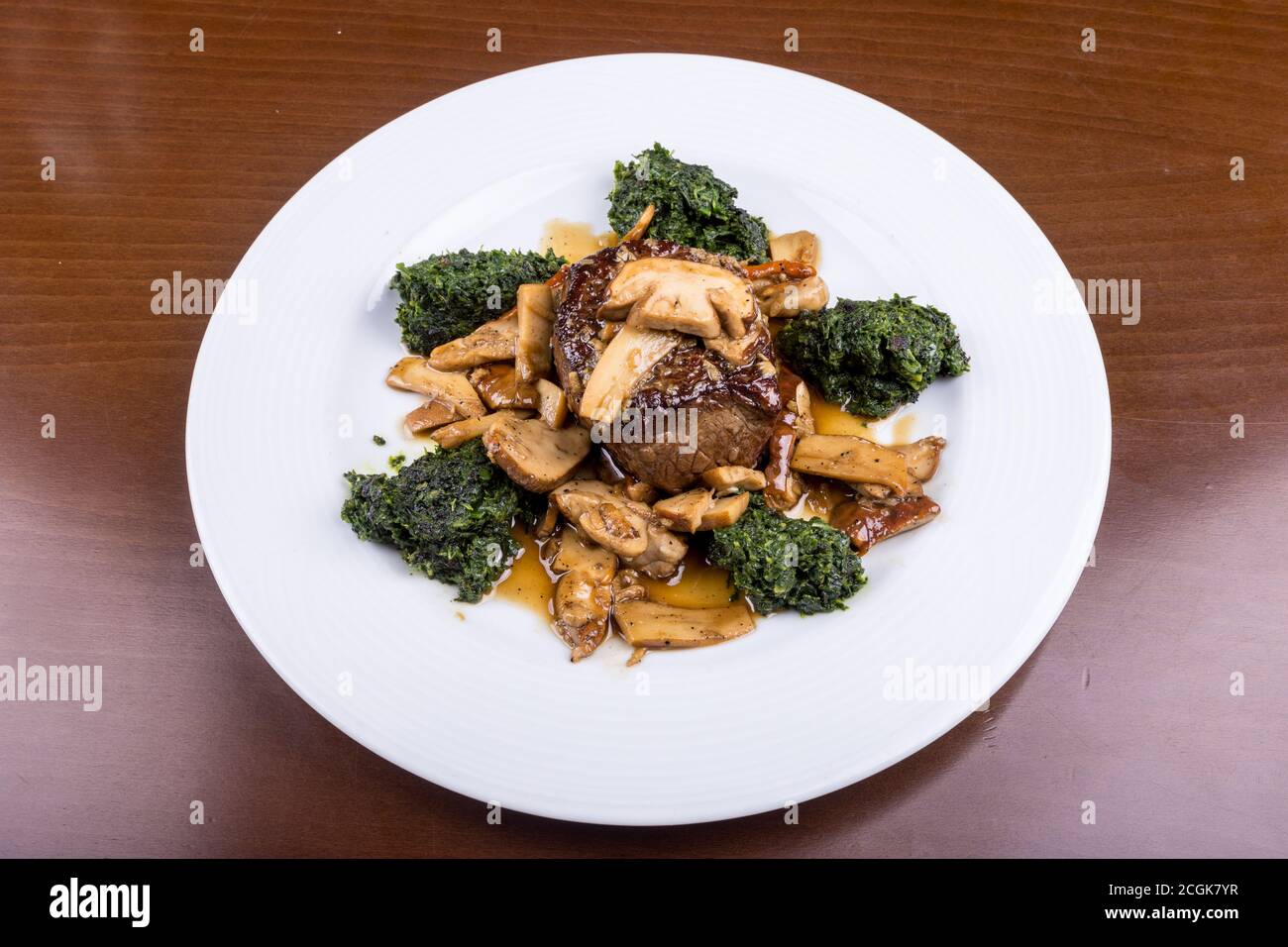 Main dish served meat with spinach and mushroom sauce Stock Photo - Alamy