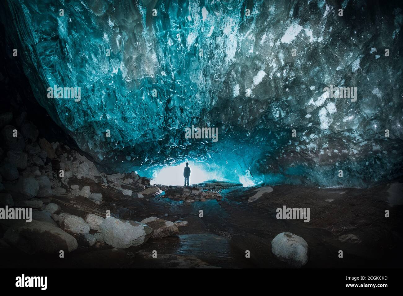 woman ice cave in a mountain glacier, a column of the purest ice hangs ...
