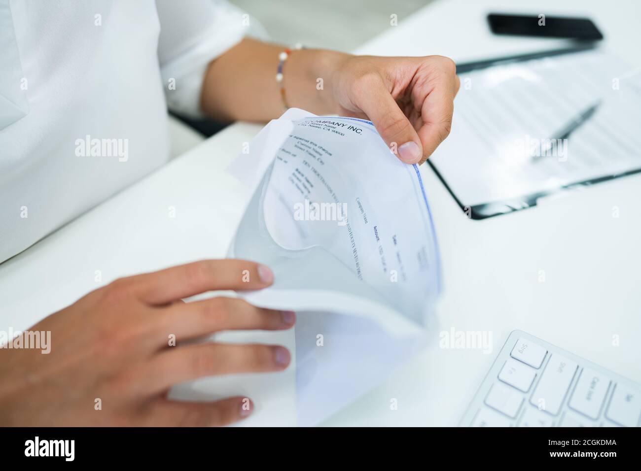 Paycheck In Open Envelope. Holding Payroll Cheque Stock Photo - Alamy