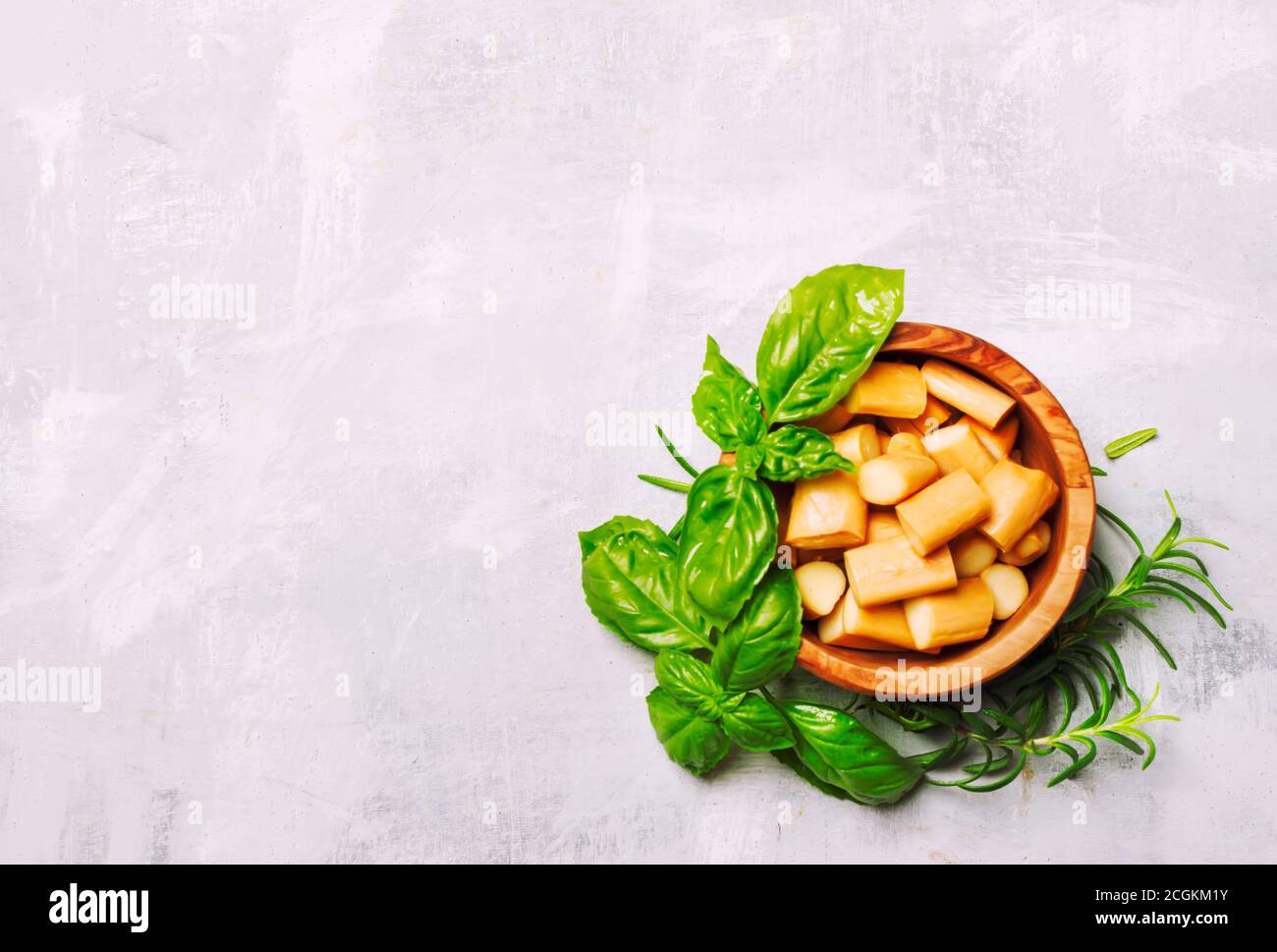 Traditional smoked chechil cheese in bowl with spicy herbs, top view ...