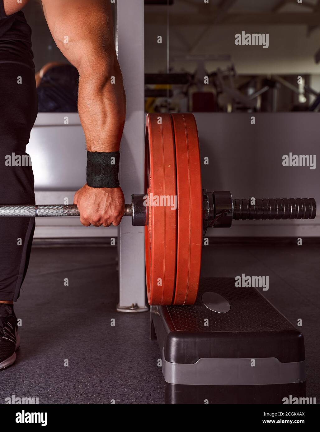 The man's hand holds a barbell neck with red discs. Contra photo Stock ...