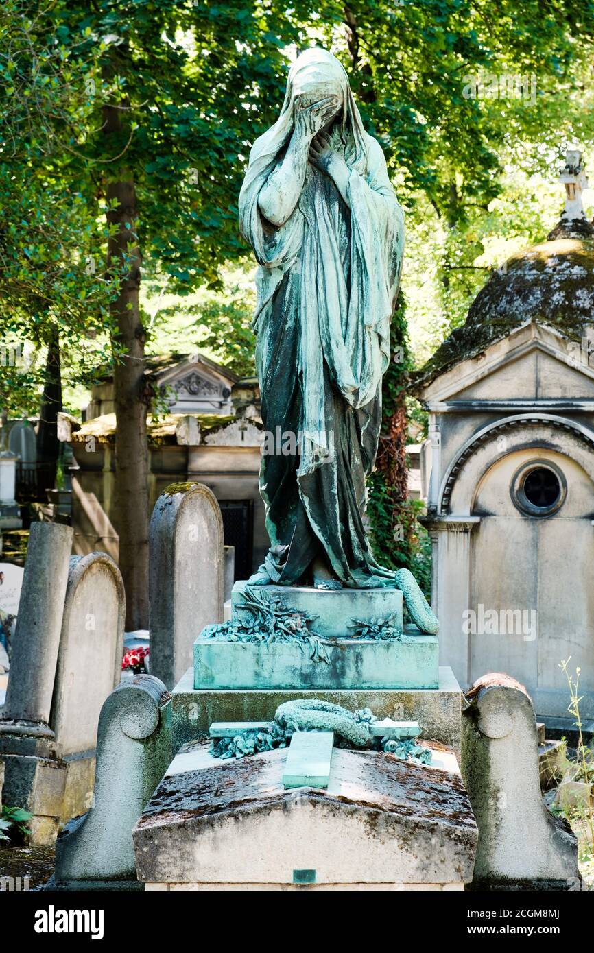 Statue of a weeping young woman at the Pere Lachaise cemetery in Paris ...