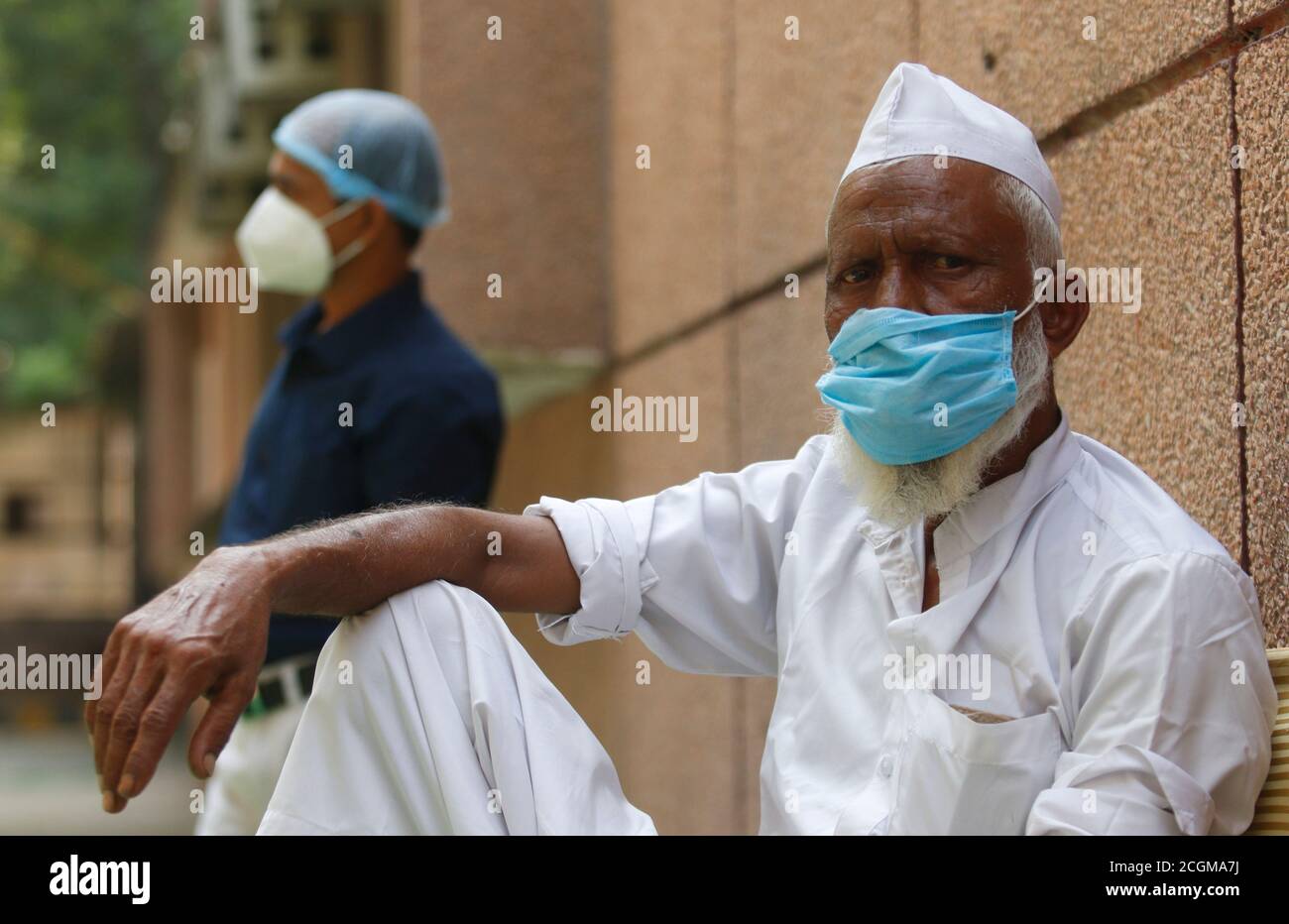 A resident wearing face mask waits outside for a Covid-19 Rapid Antigen ...
