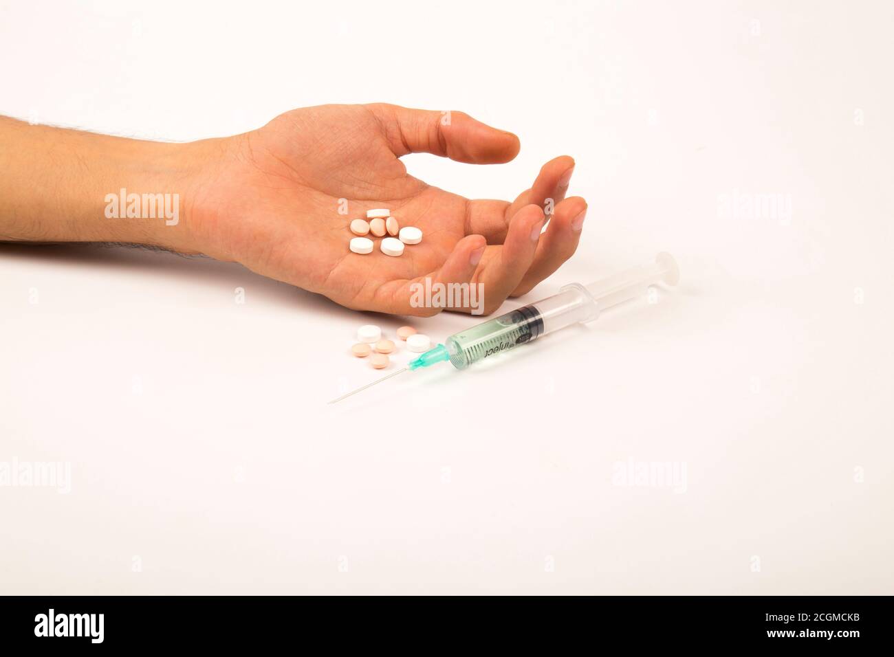 Drug addiction concept - passive hand with coat, pills and injection ...