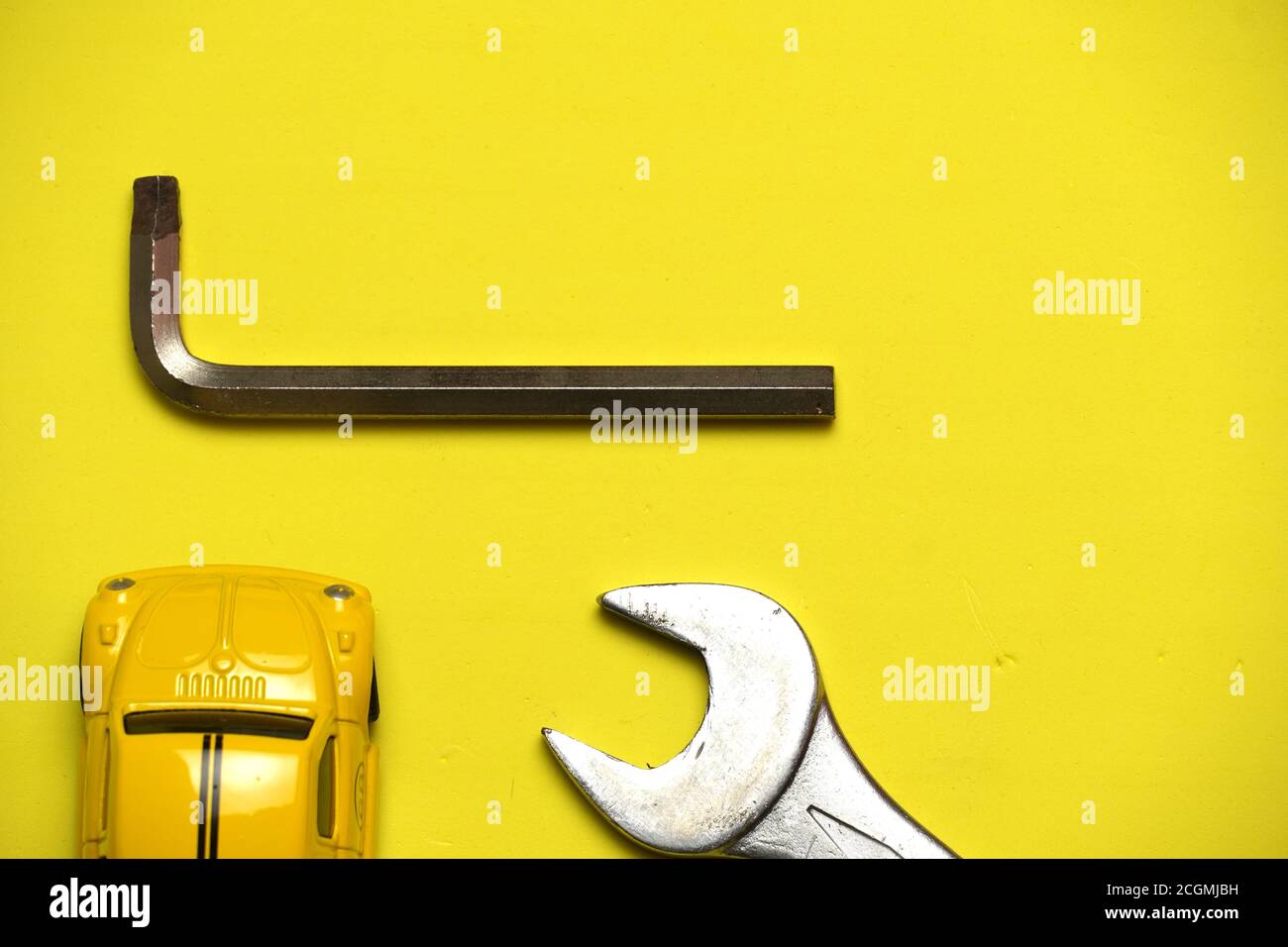 top view of a car and tools on a yellow colorful background. flat lay ...