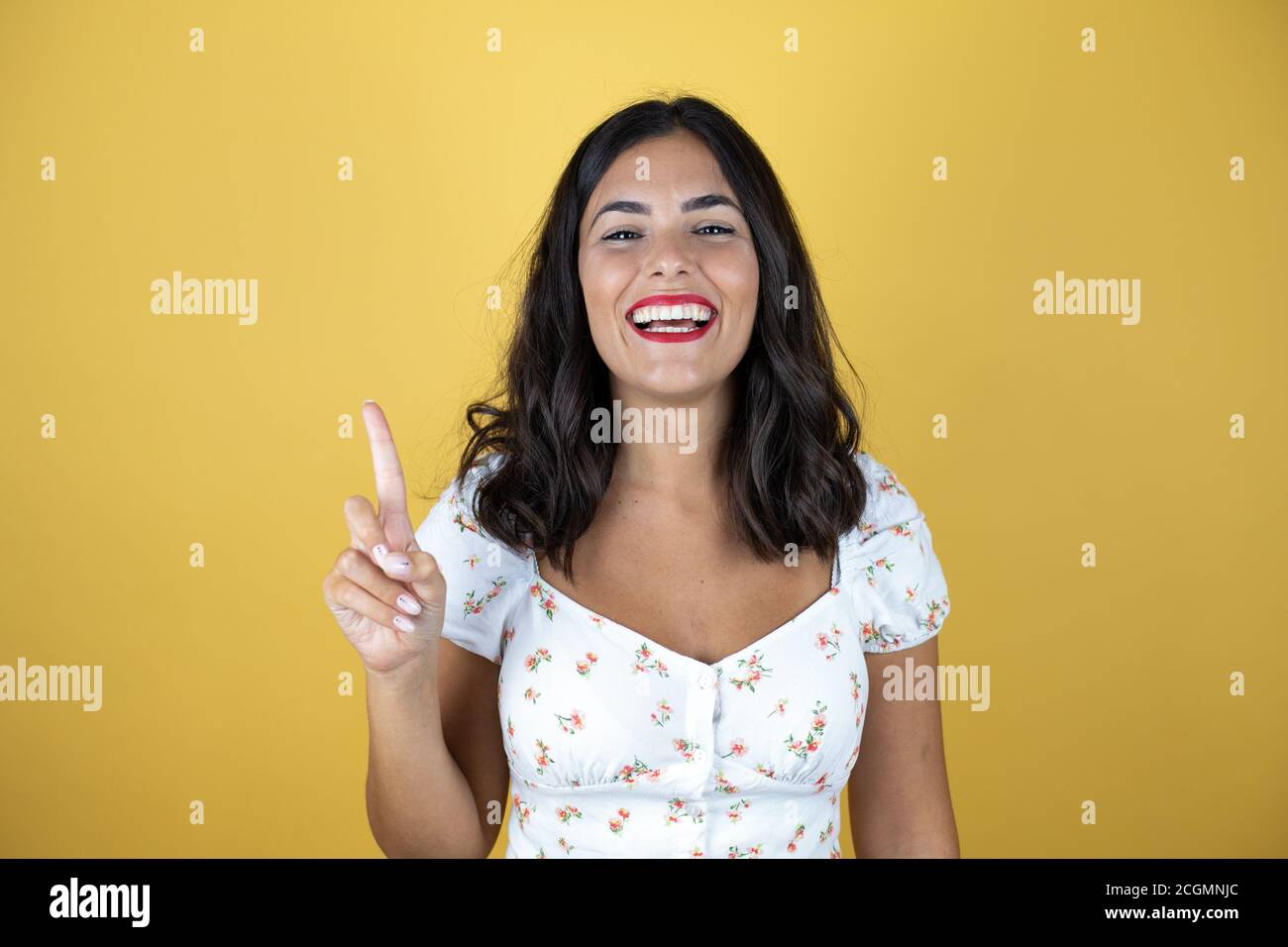 Beautiful woman over yellow background showing and pointing up with ...