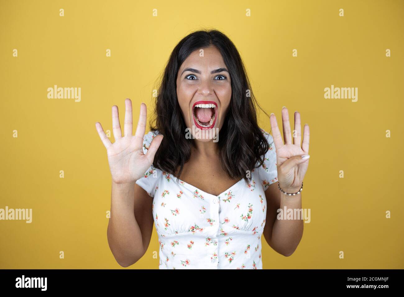 showing and pointing up with fingers number nine while smiling ...