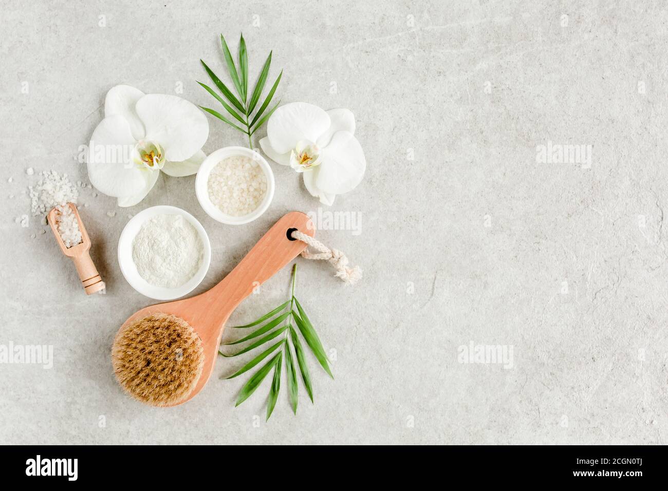Spa treatment concept. Natural spa cosmetics products, sea salt, massage brush, tropic palm ...