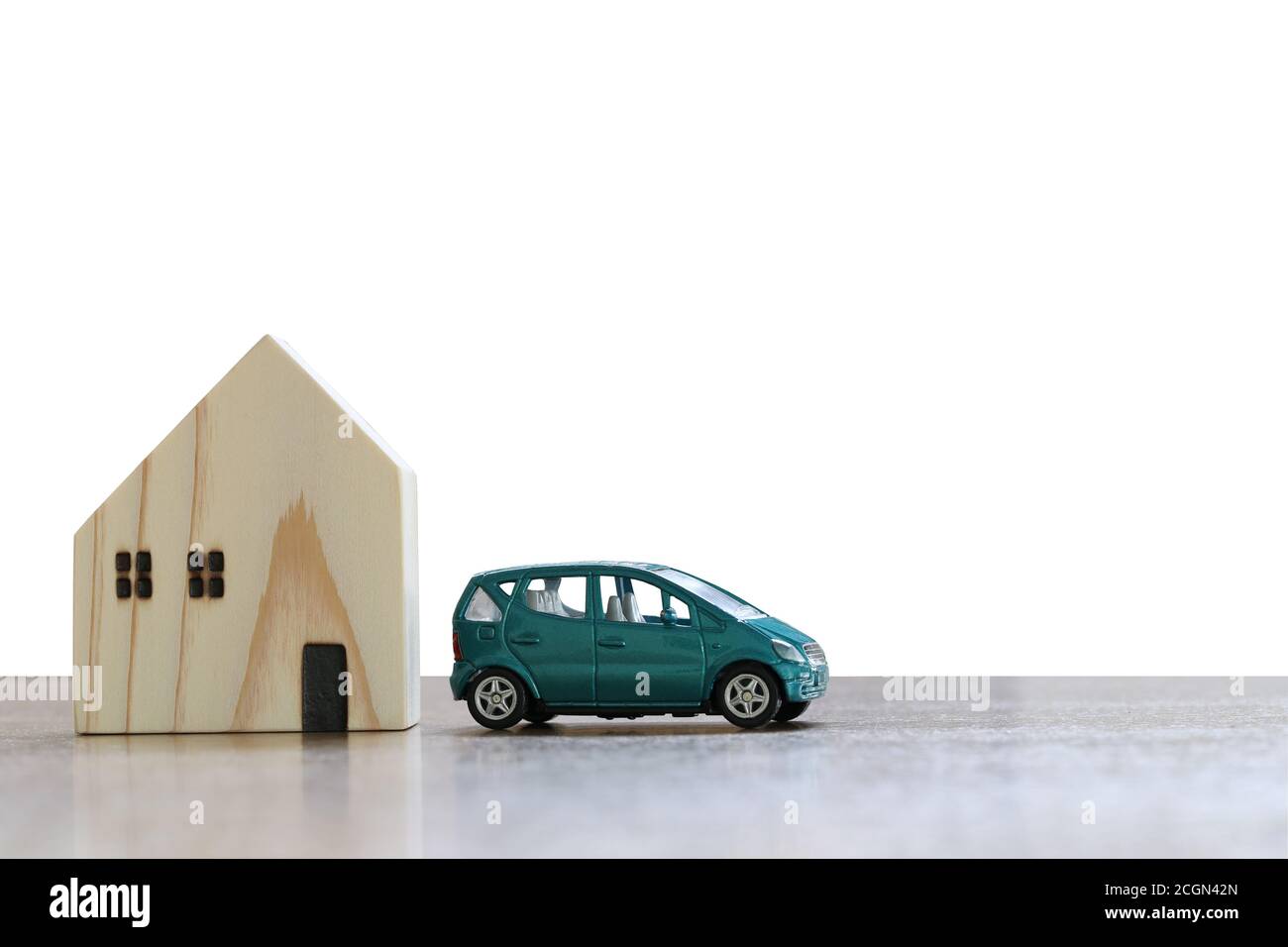 Car and a toy house on the wooden floor isolated on white background ...