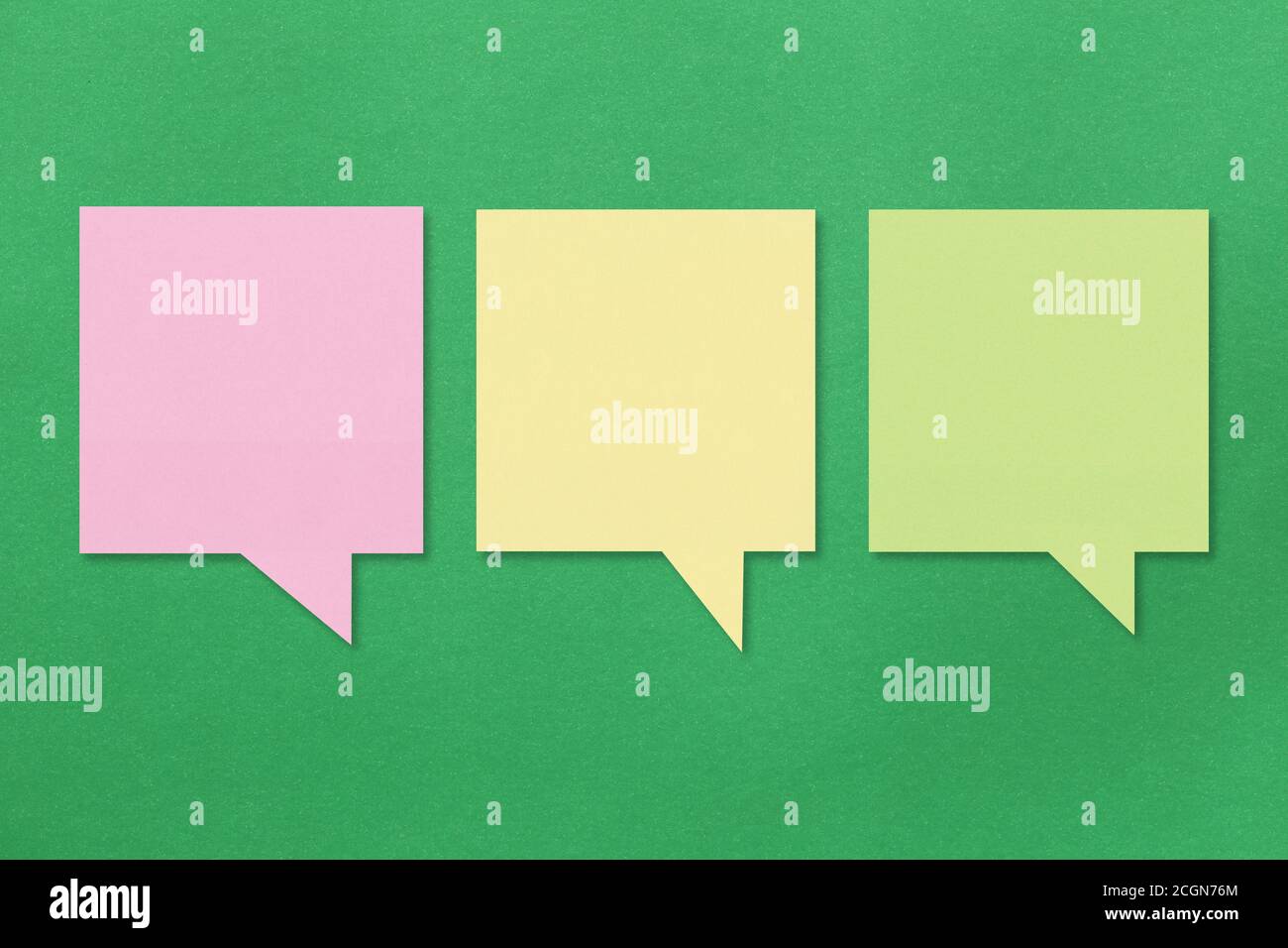 Colorful square note paper on green paper background and have copy ...