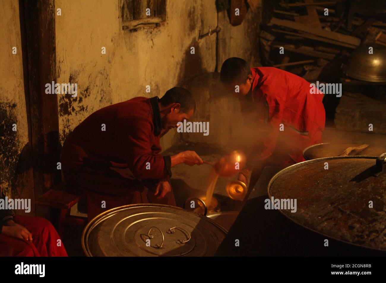 Cook and apprentice Monks making Yak Butter Tea, inside Muli Monastery ...