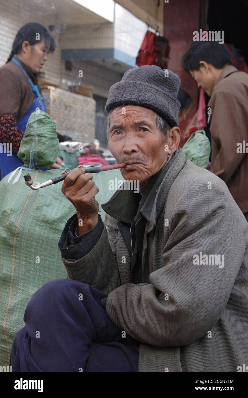 Man smoking pipe in the street, Qiaoja, north Yunnan Province, China ...