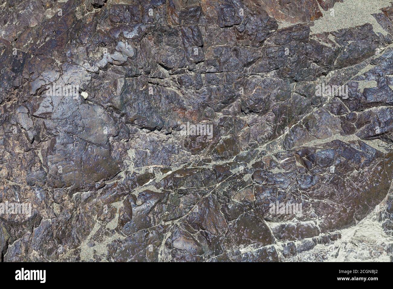 Close-up of a stone river bank with cracks in the design texture of ...