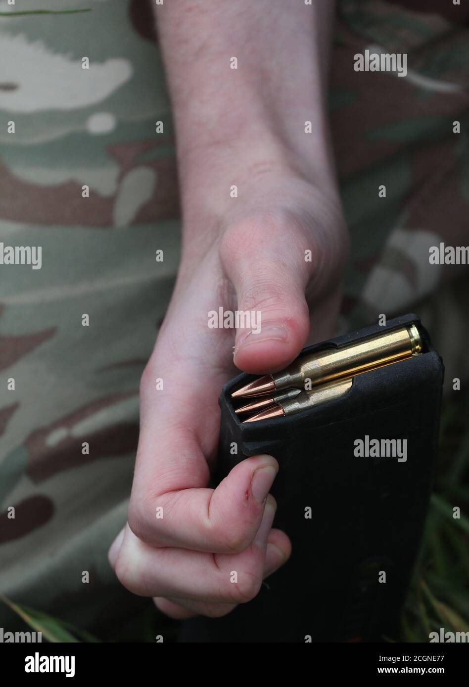 A soldier from the Royal Scots Dragoon Guards loads bullets into a ...