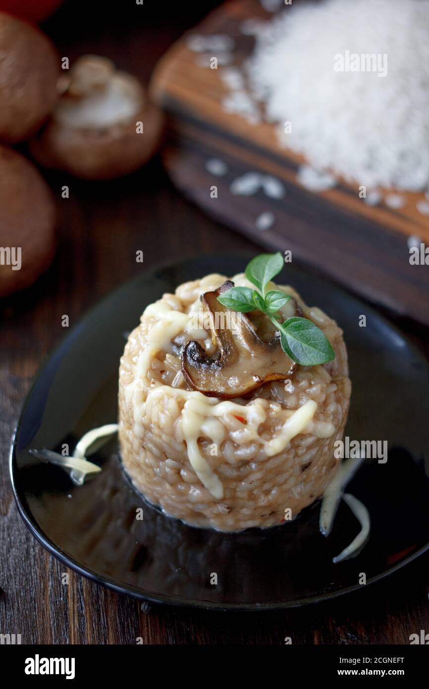 Italian mushroom risotto on black ceramic plate over table Stock Photo ...