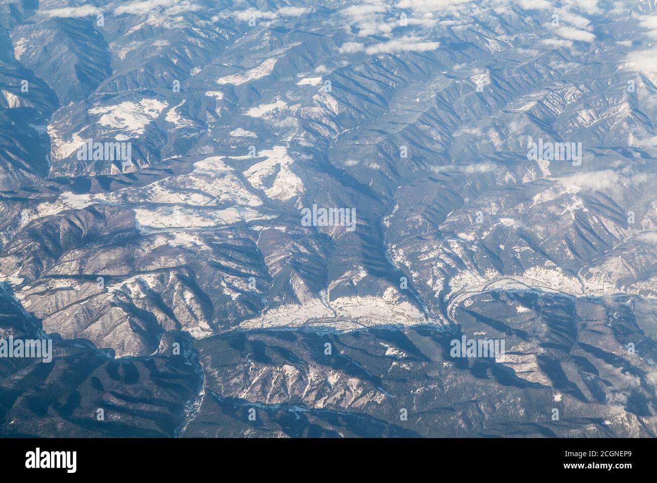 Aerial view of snowy mountain tops with white clouds Stock Photo - Alamy