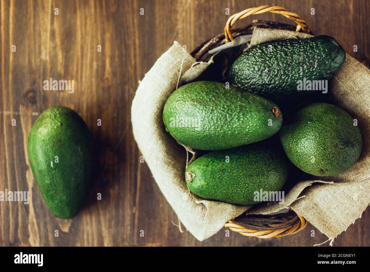 Avocado fruits in basket on wooden rustic background Stock Photo - Alamy