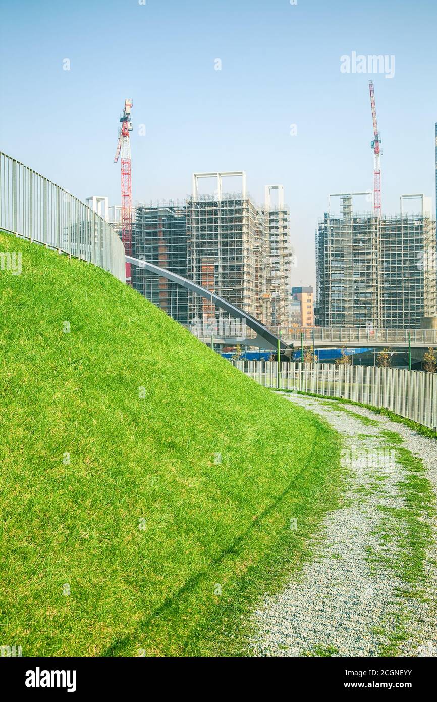 Walking path with green grass and construction site Stock Photo - Alamy