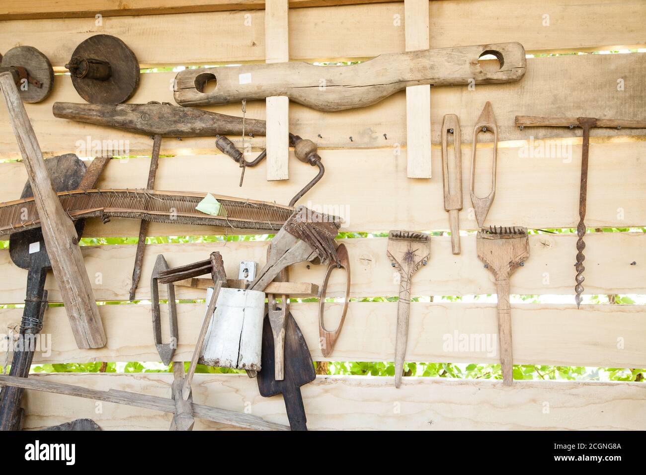 Different wooden tools for household works hanging on wall Stock Photo ...