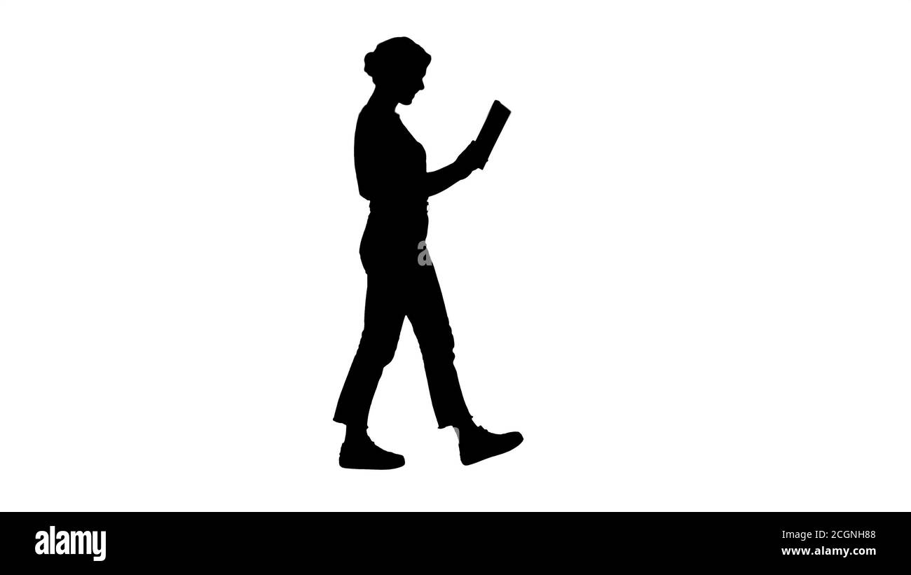Silhouette Happy woman walking with tablet Stock Photo - Alamy