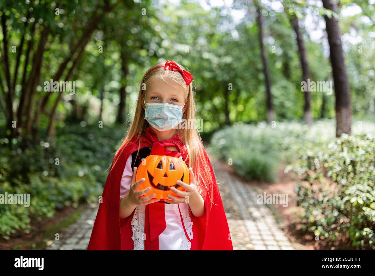 Portrait of cute Little Girl in costume of red hat in the park. Happy ...