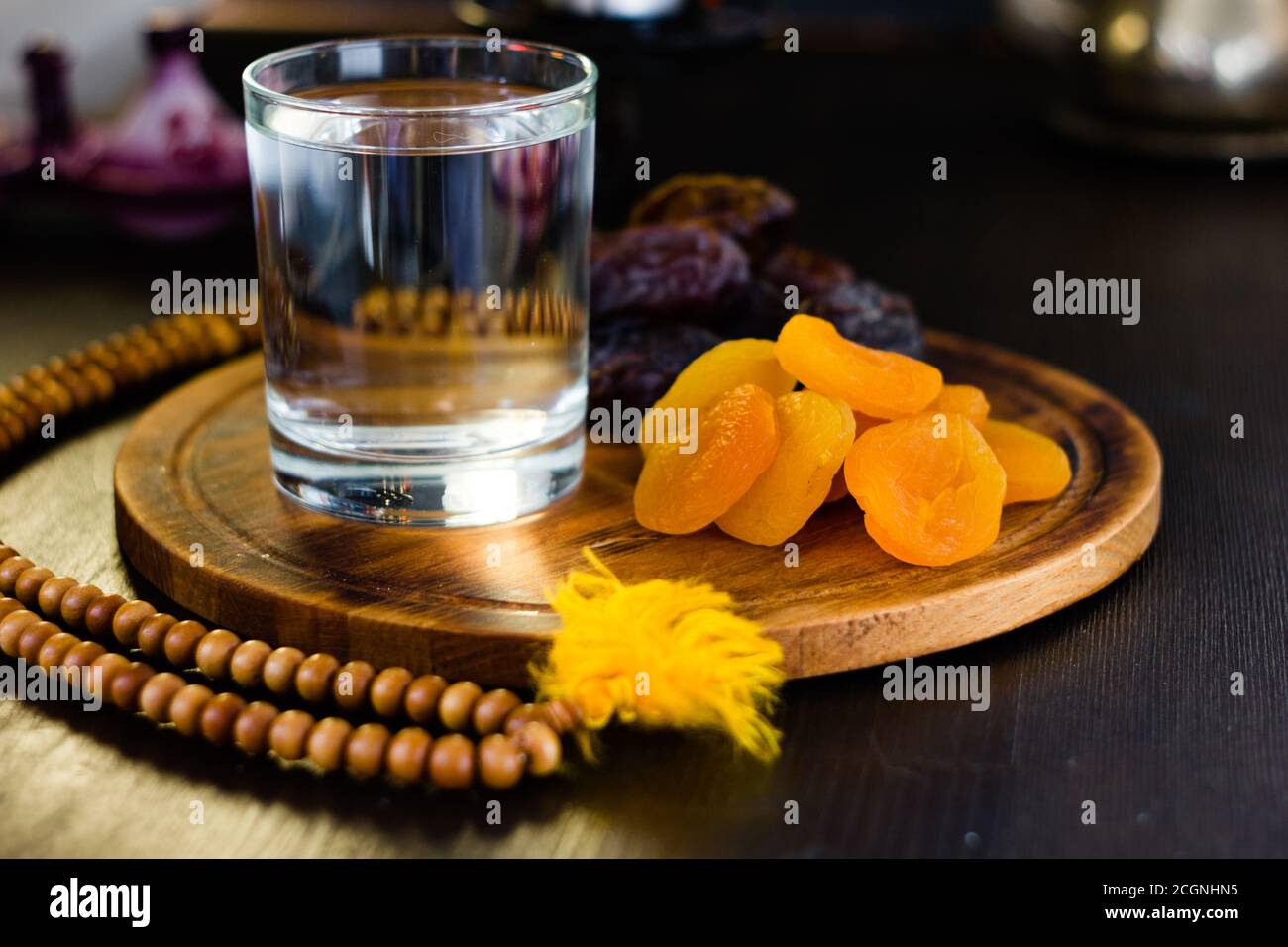 ramadan water for iftar on wooden board with rosary and dried fruits ...