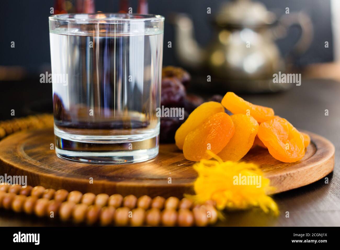 ramadan water for iftar on wooden board with rosary and dried fruits ...