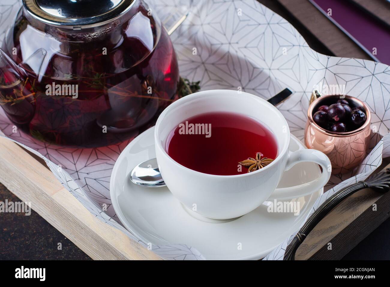 Hot berry tea in white cup with spice anise star and thyme on dark ...