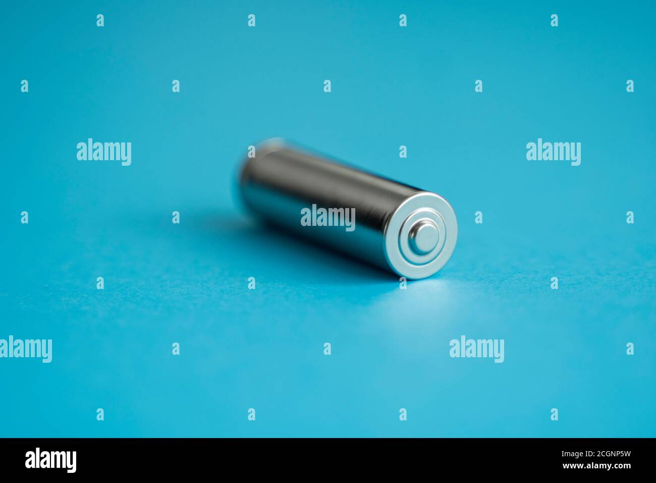 A single rechargeable battery on blue background. Silver alkaline AA ...