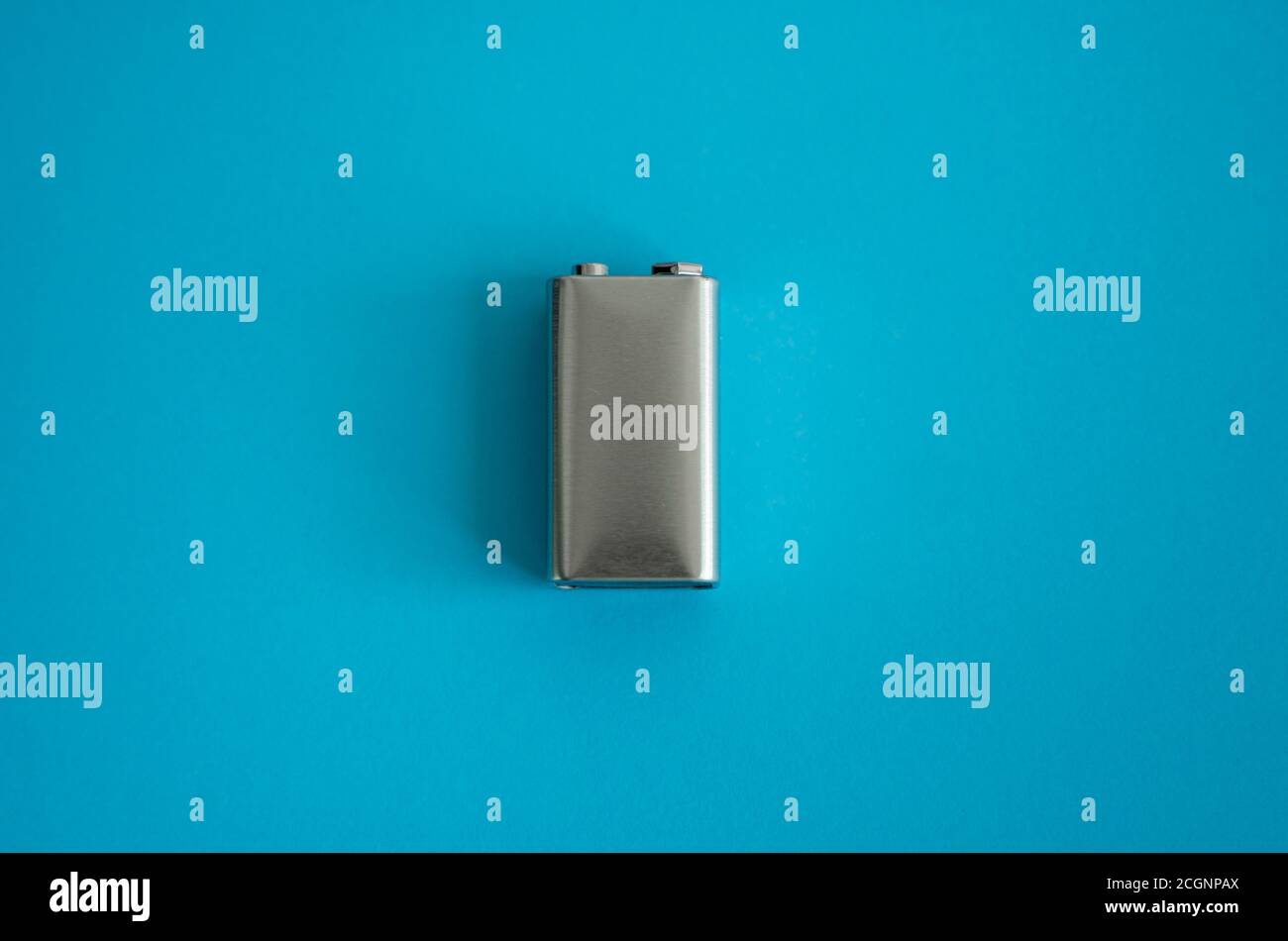 High voltage battery on a blue background. Silver Volt battery. 9V ...