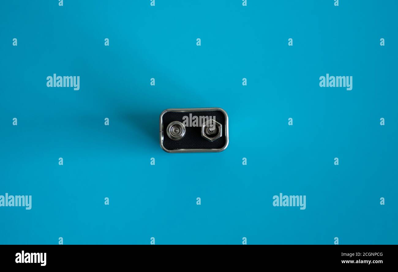High voltage battery on a blue background. Silver Volt battery. 9V ...