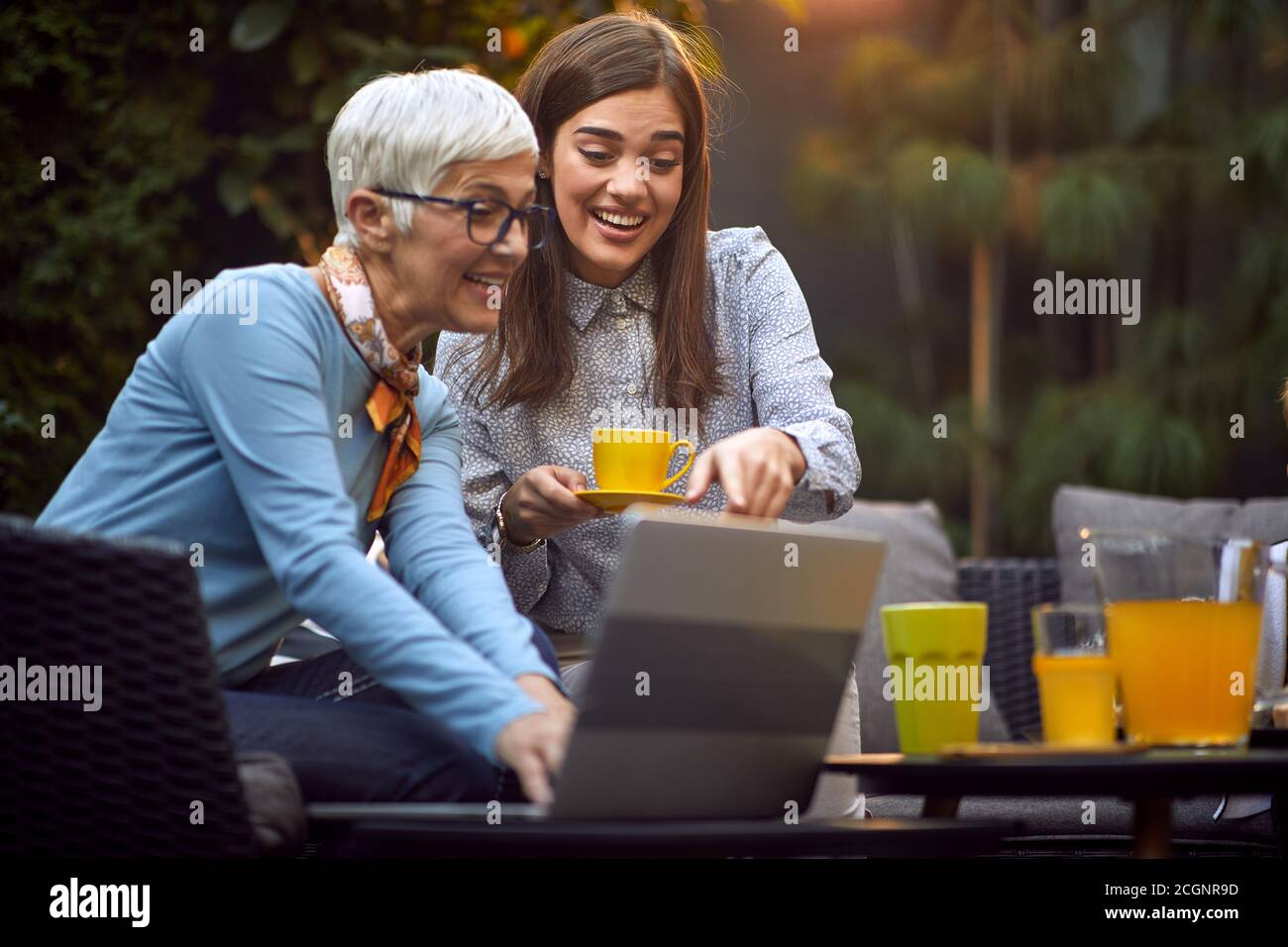 Old Cheerful Mother And Young Adult Daughter Watching Content On Laptop