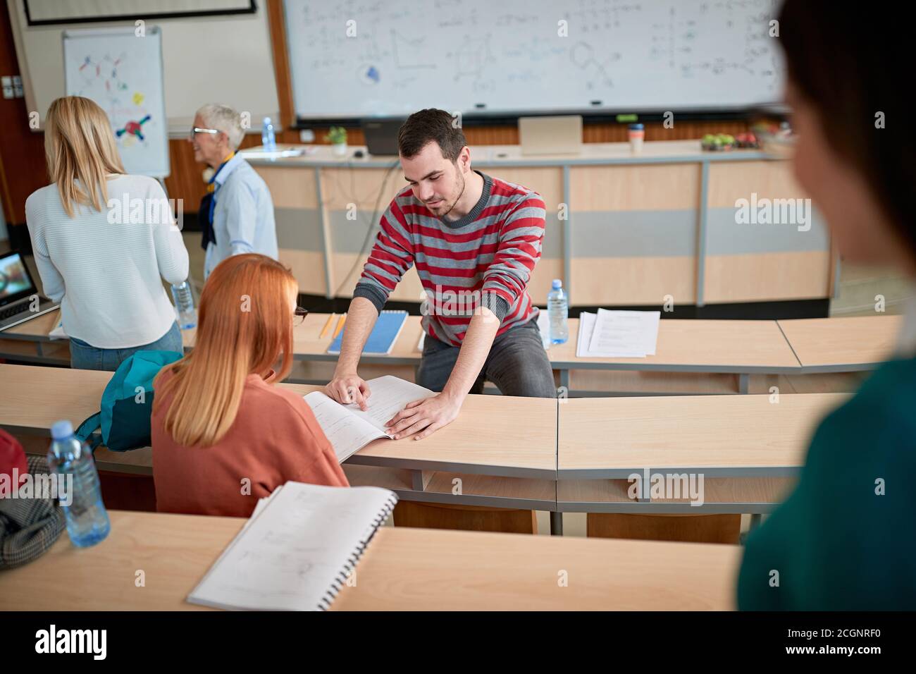 Student helping colleague in a break of a lecture at amphitheatre Stock ...