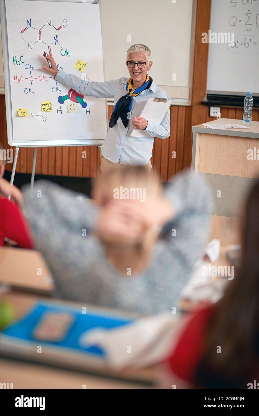 Female professor presenting the lecture on a board in an amphitheatre ...