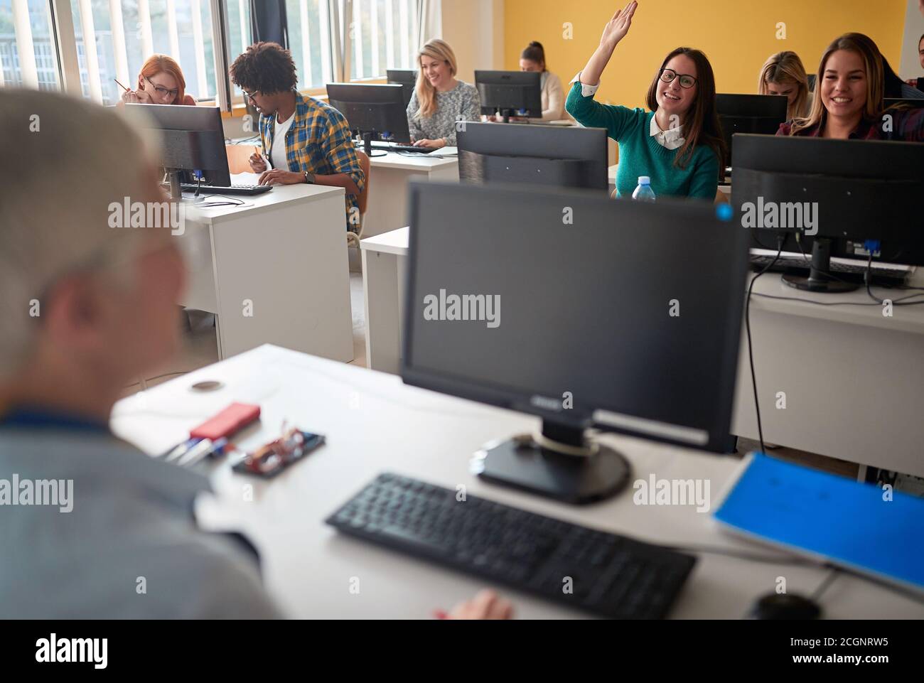 A female students rising hand for question at a lecture in the ...