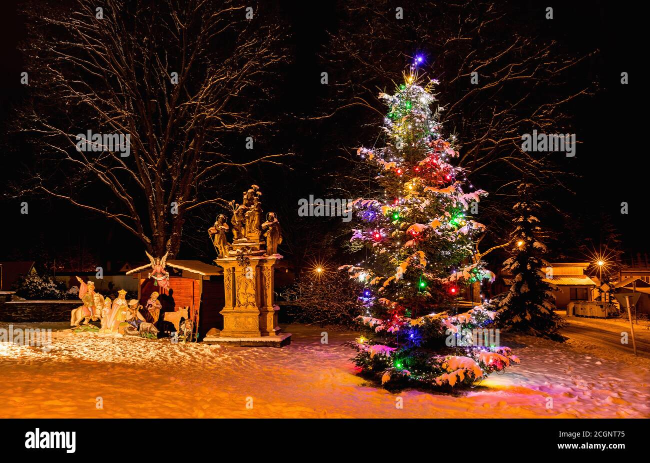 Lighted Christmas tree in a picturesque village. Evening by the ...