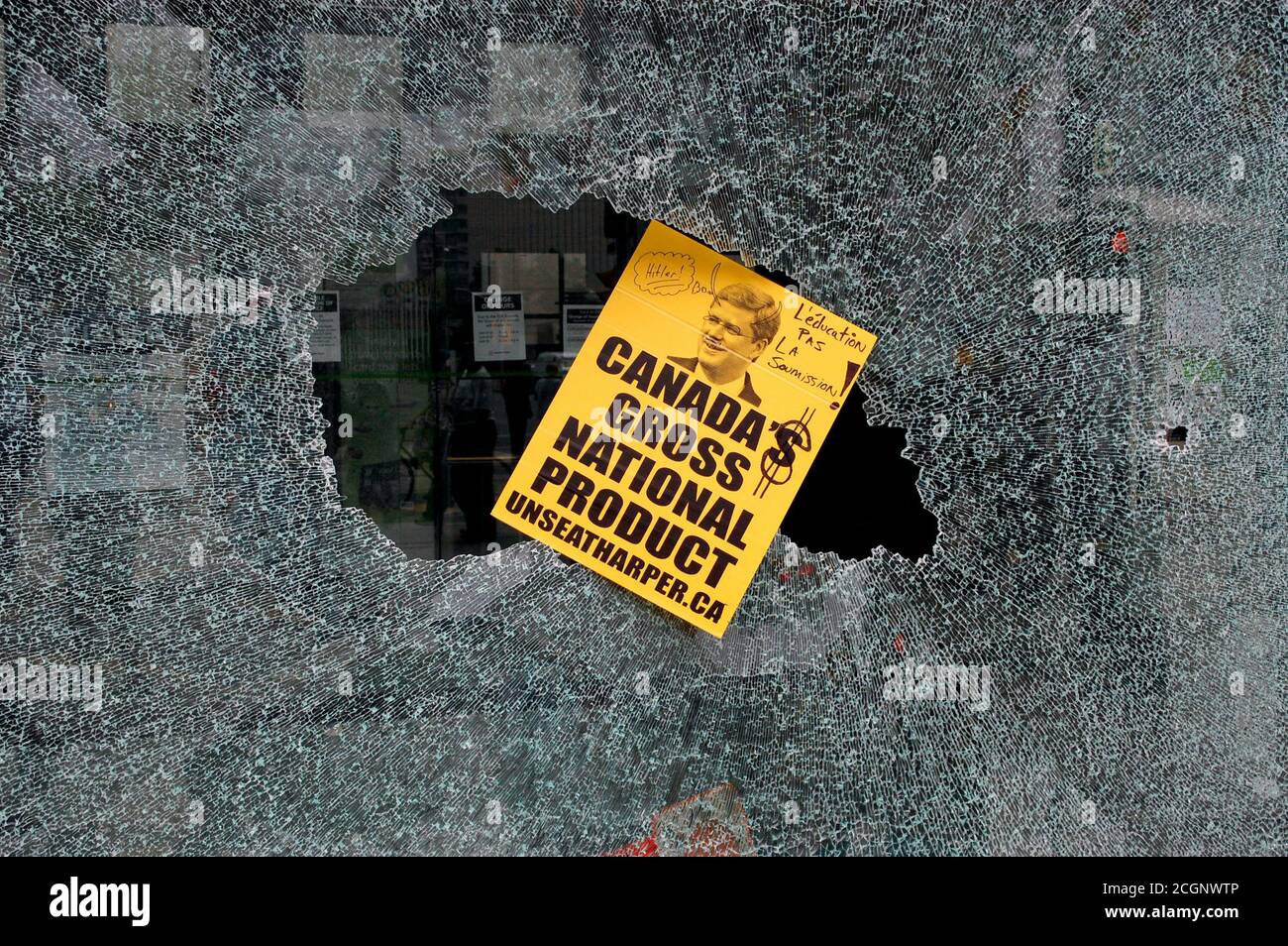 Protest sign in smashed shop window, downtown Toronto during G20 summit ...
