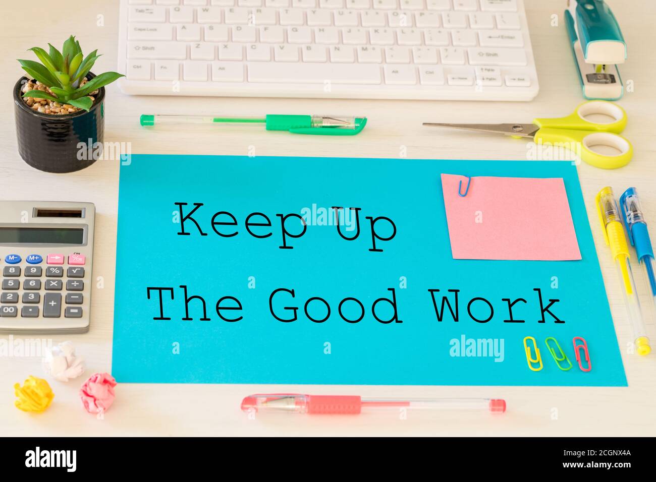 A large blue card on the desk with the words Keep Up The Good Work ...