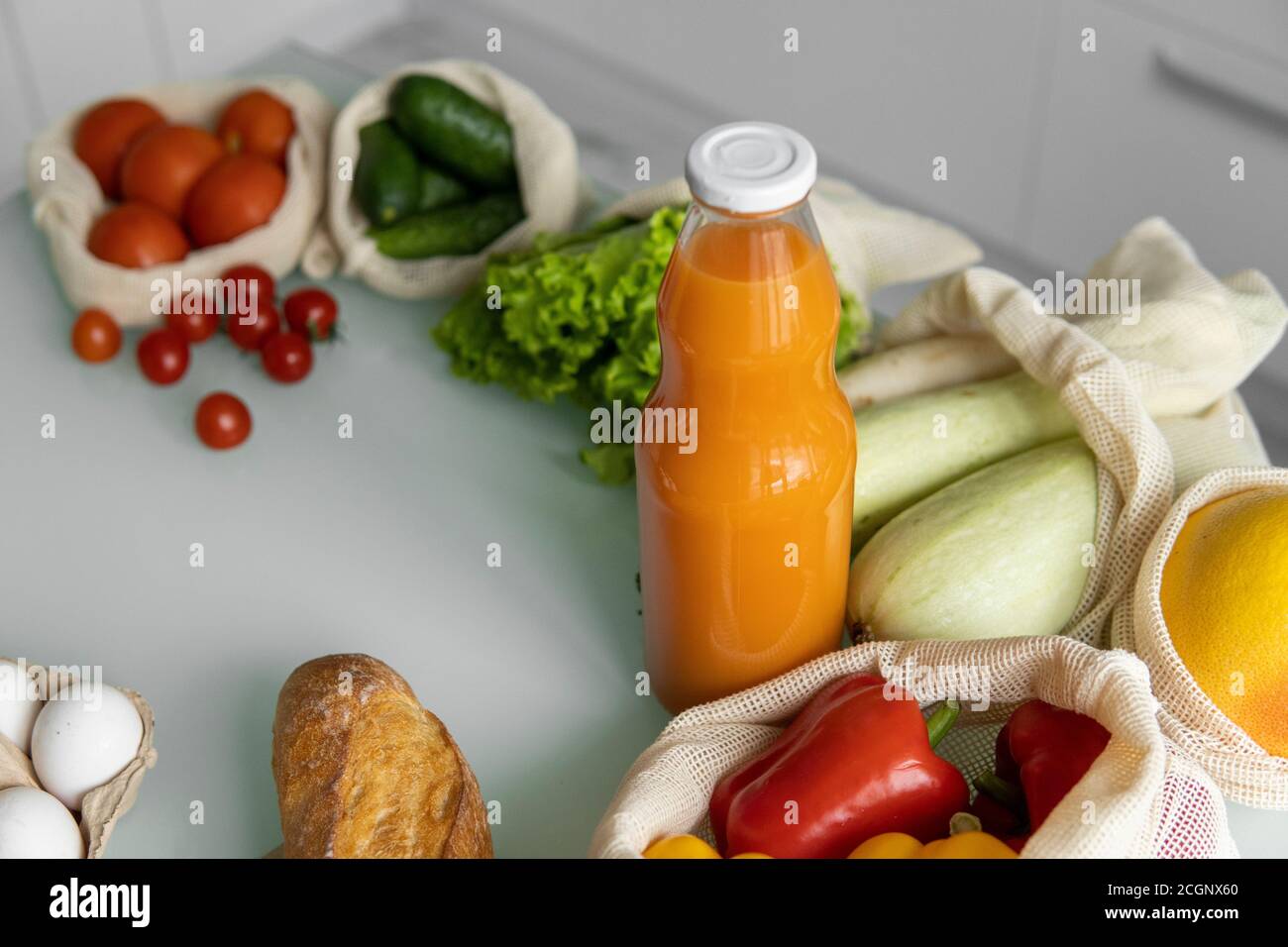 Vegetables, fruits, eggs in reusable eco cotton bags on table. Zero ...
