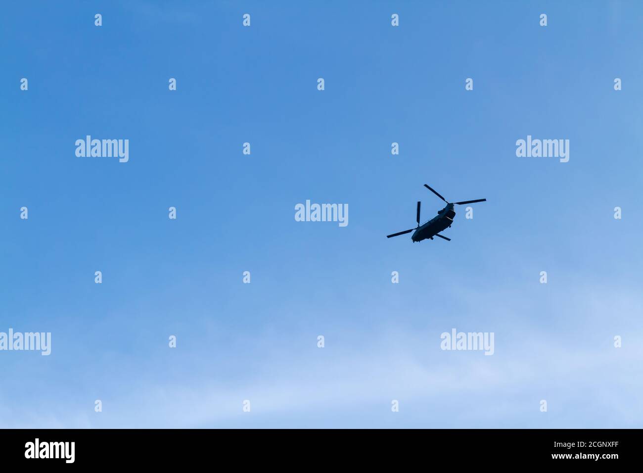 Chinook flying across blue sky Stock Photo - Alamy