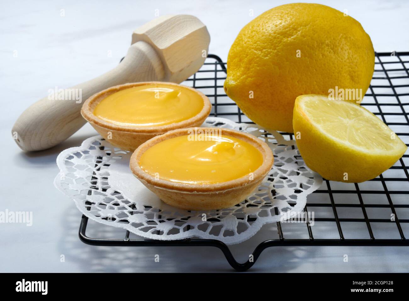 Lemon tartlets and lemon on a cake rack hi-res stock photography and ...