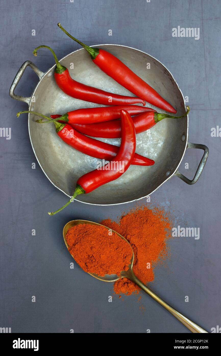 Chilli powder in spoon and chilli peppers in shell hi-res stock ...