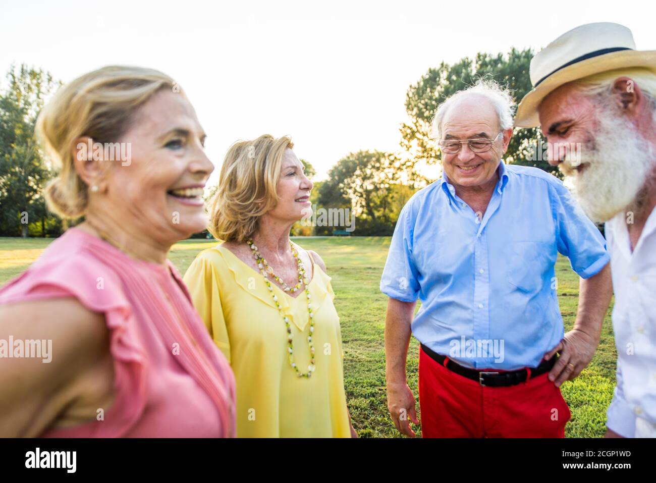 Group of youthful seniors having fun outdoors - Four pensioners bonding ...