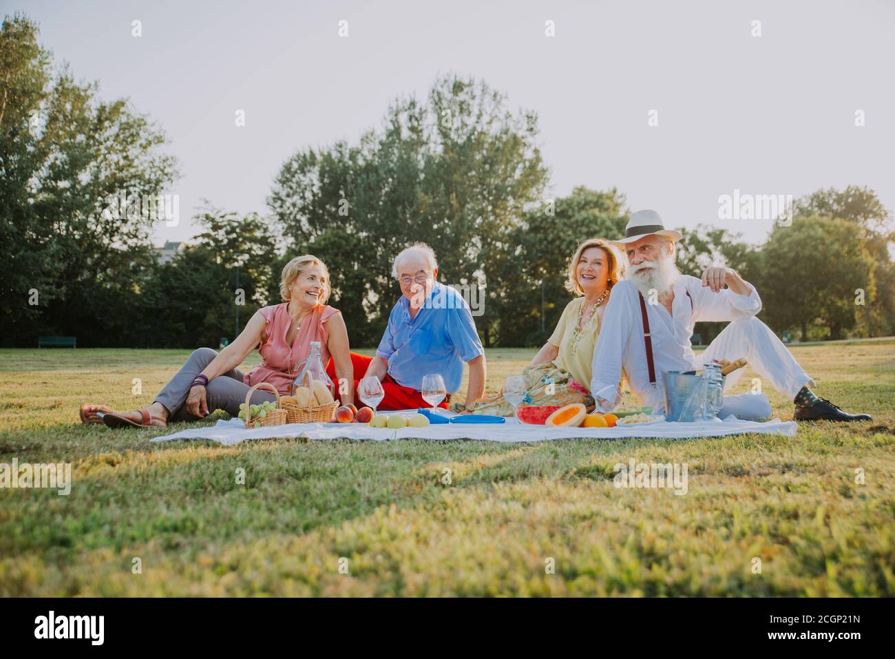 Group of youthful seniors having fun outdoors - Four pensioners bonding ...