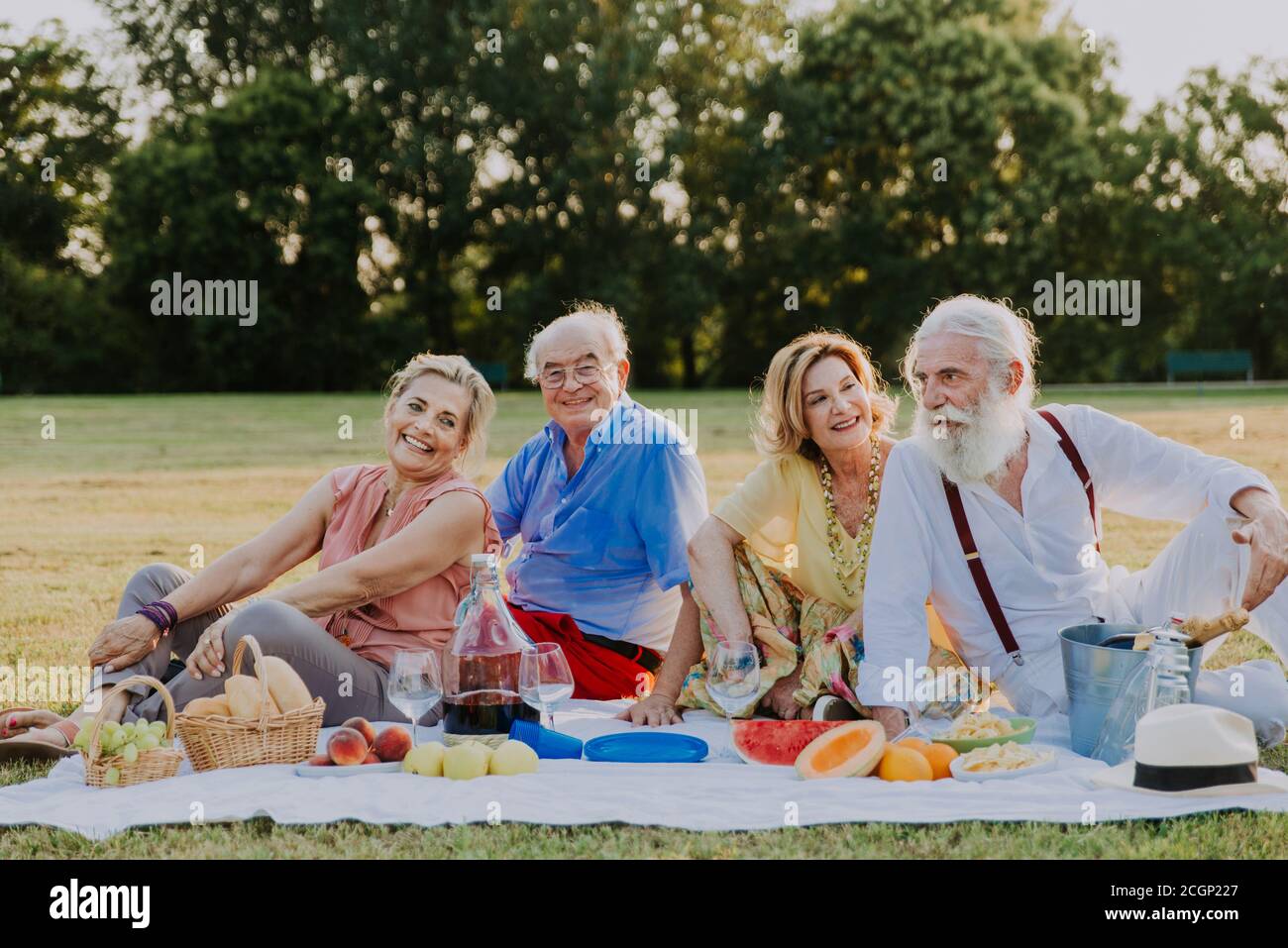 Group of youthful seniors having fun outdoors - Four pensioners bonding ...