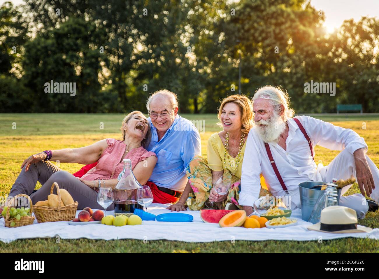 Group of youthful seniors having fun outdoors - Four pensioners bonding ...