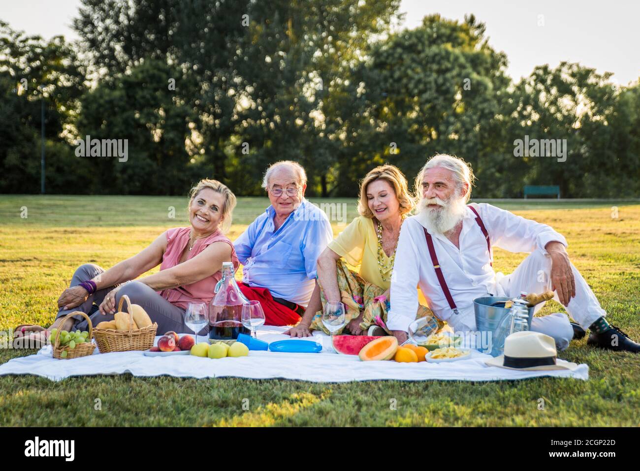 Group of youthful seniors having fun outdoors - Four pensioners bonding ...
